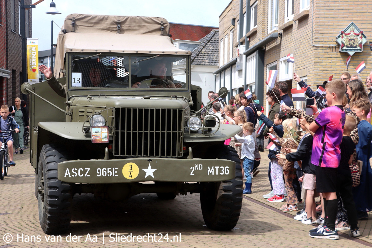 Kerkbuurt met legervoertuigen en vlaggetjes even in sfeer van ...
